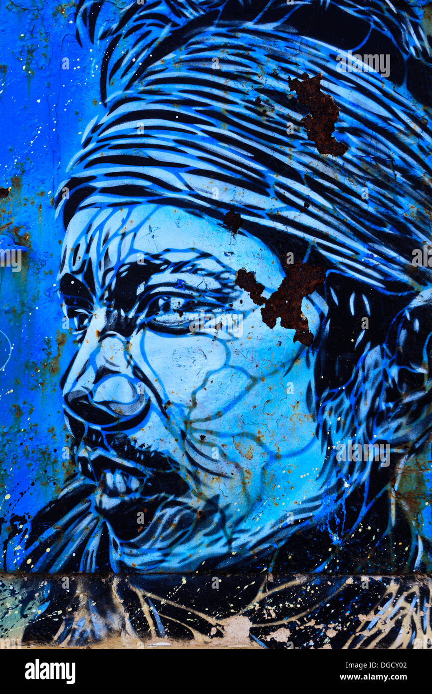Damage scars blue portrait of Berber man on a large wall mural in city ...
