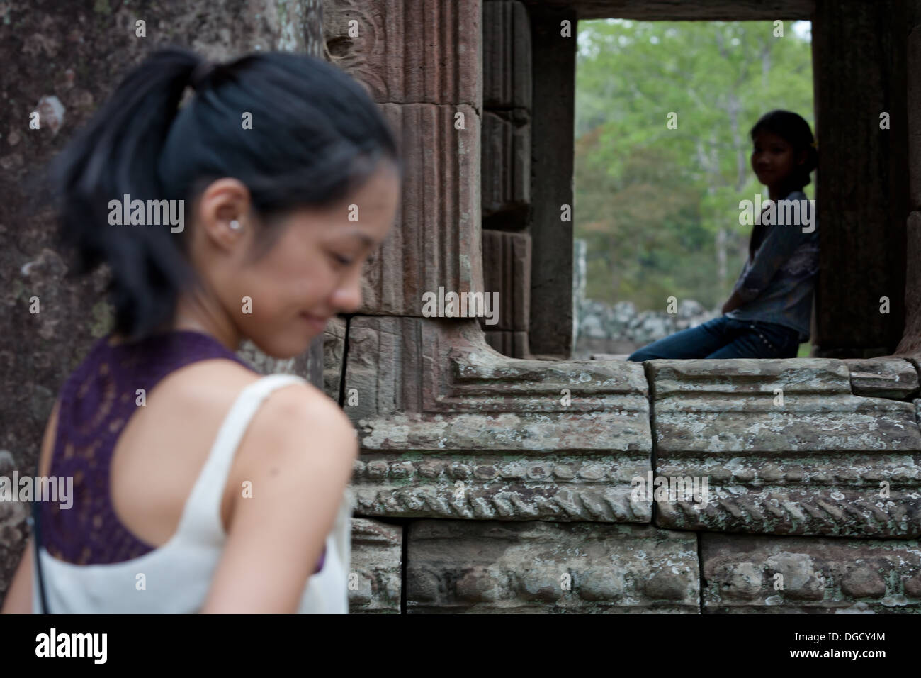 Two young women amid the intricate stonework of the Angkor Wat temple ...