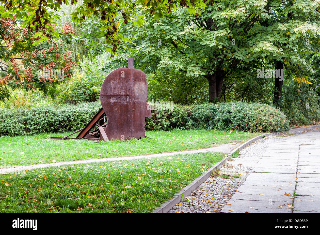 Public sculpture - Rusty head silhouette in front of railway tracks and ...