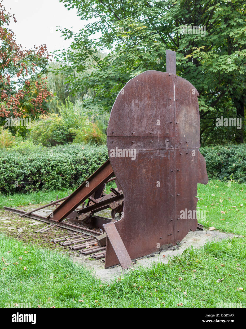 Public sculpture - Rusty head silhouette in front of railway tracks and ...