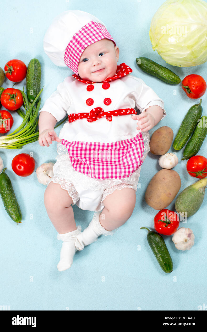 Baby cook girl wearing chef hat with fresh vegetables. Use it for a ...