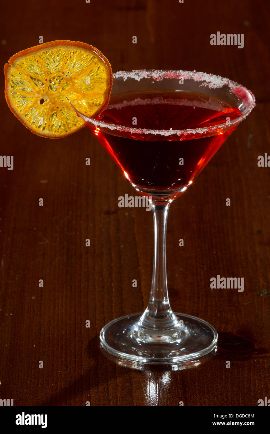 Holiday martini served on a dark bar with an orange wheel garnish Stock ...
