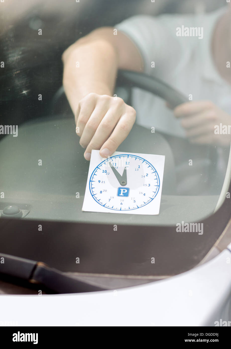 man placing parking clock on car dashboard Stock Photo - Alamy