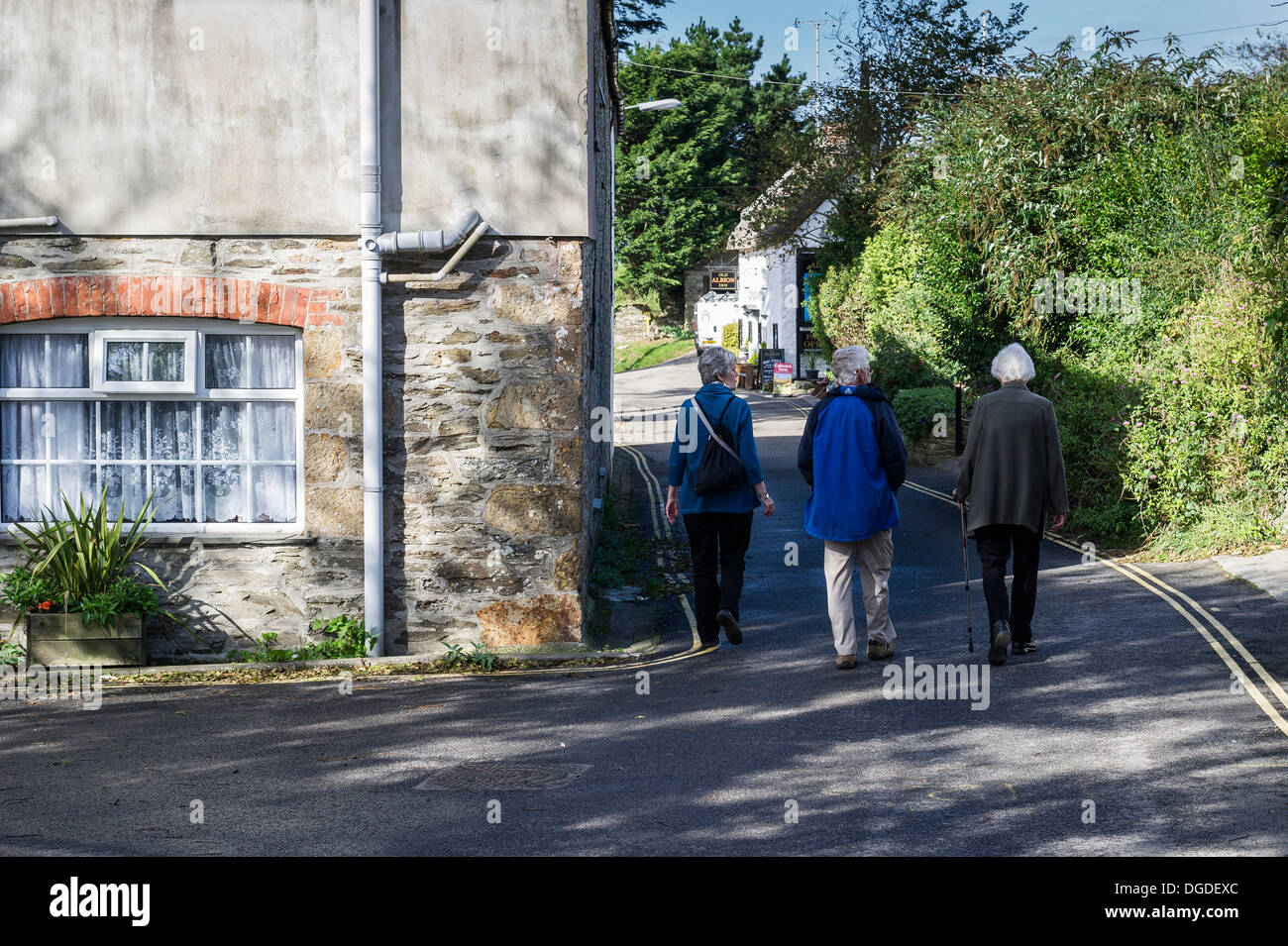 Three people strolling through the Crantock Village in Cornwall Stock ...
