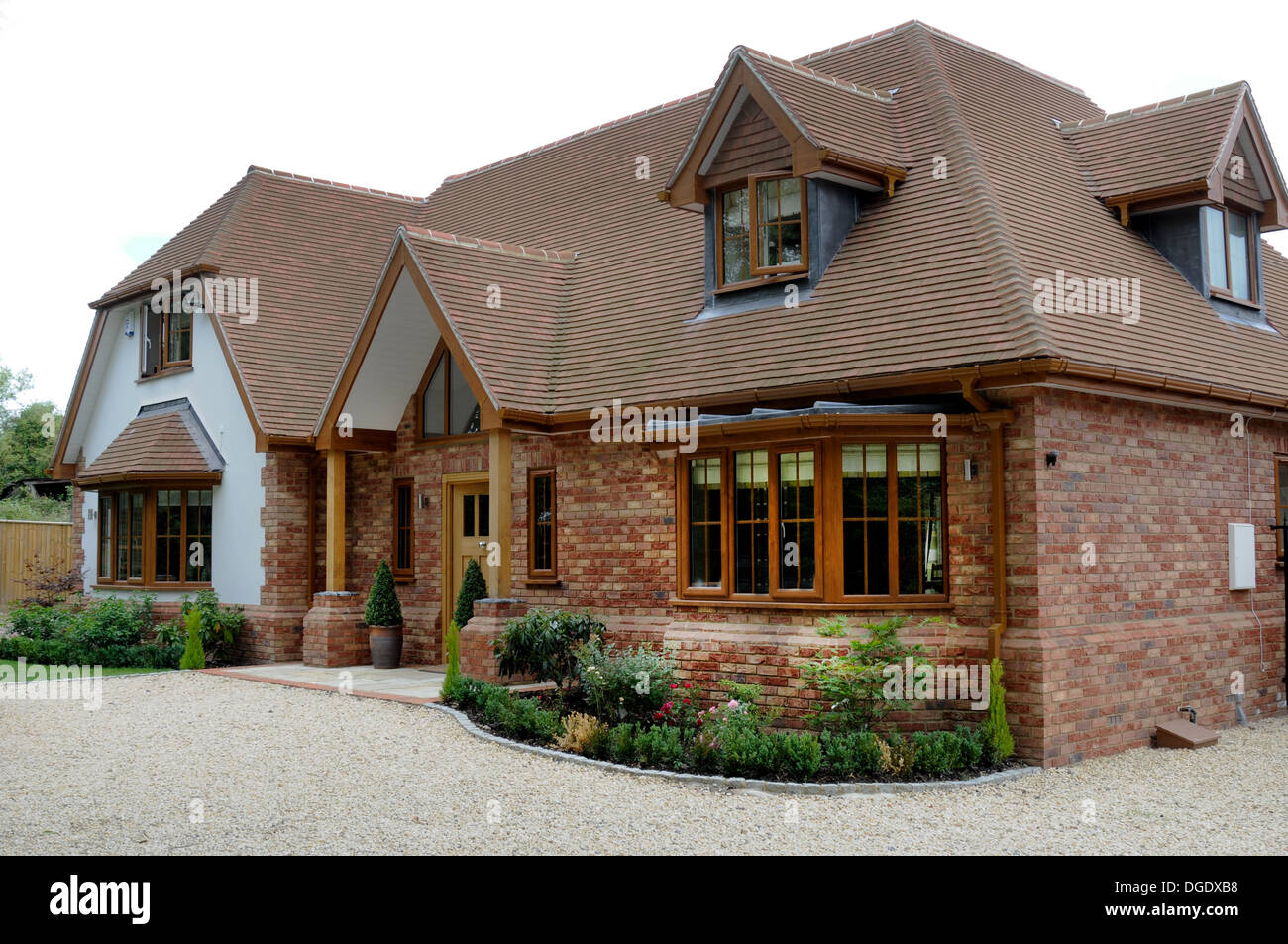 A modern detached brick built house with gravel drive and plants Stock ...
