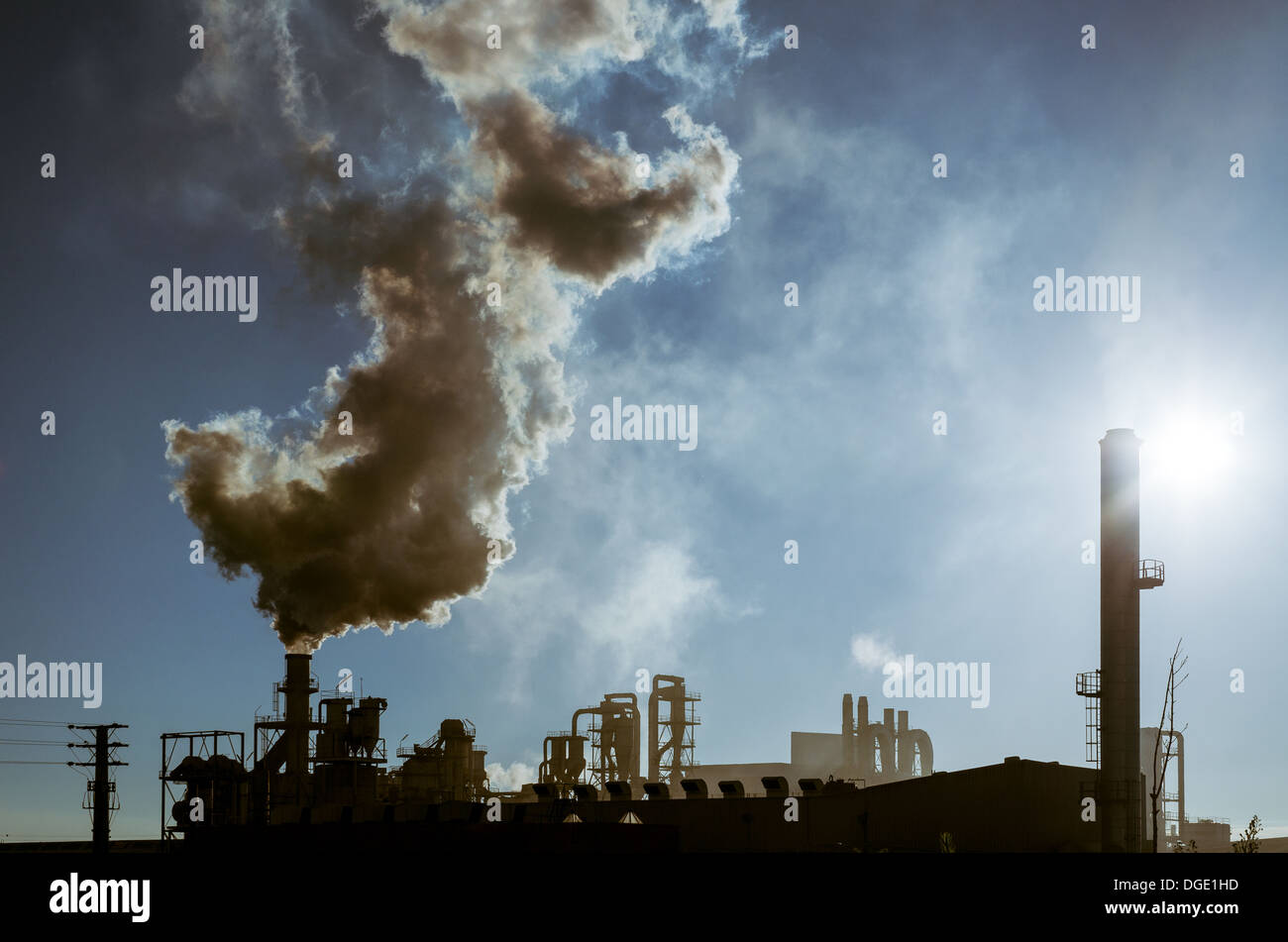 Smoking chimney at sunset on industrial buildings complex Stock Photo ...