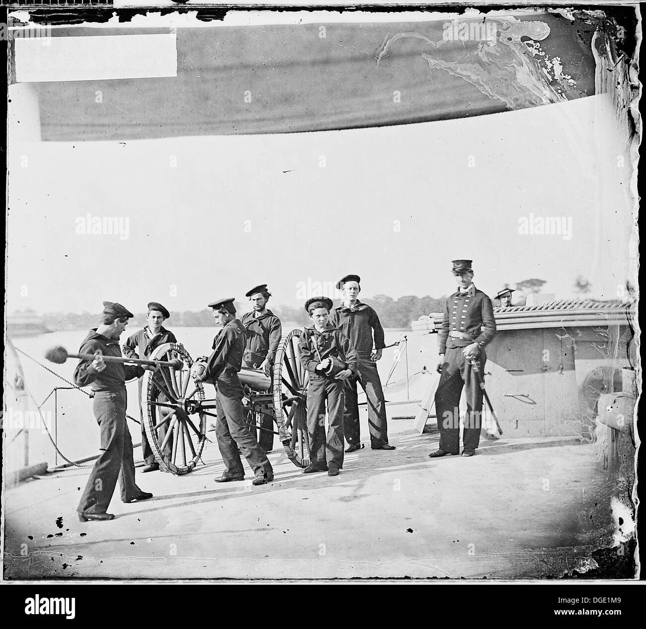 This photograph shows a gun crew operating a naval deck gun. The crew ...