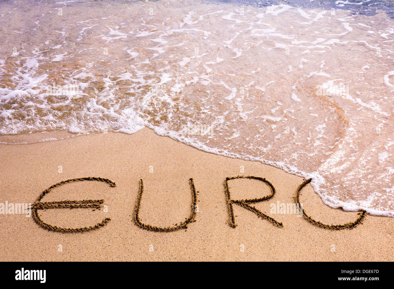 euro word written in the sand on a beach, washed away by sea water ...