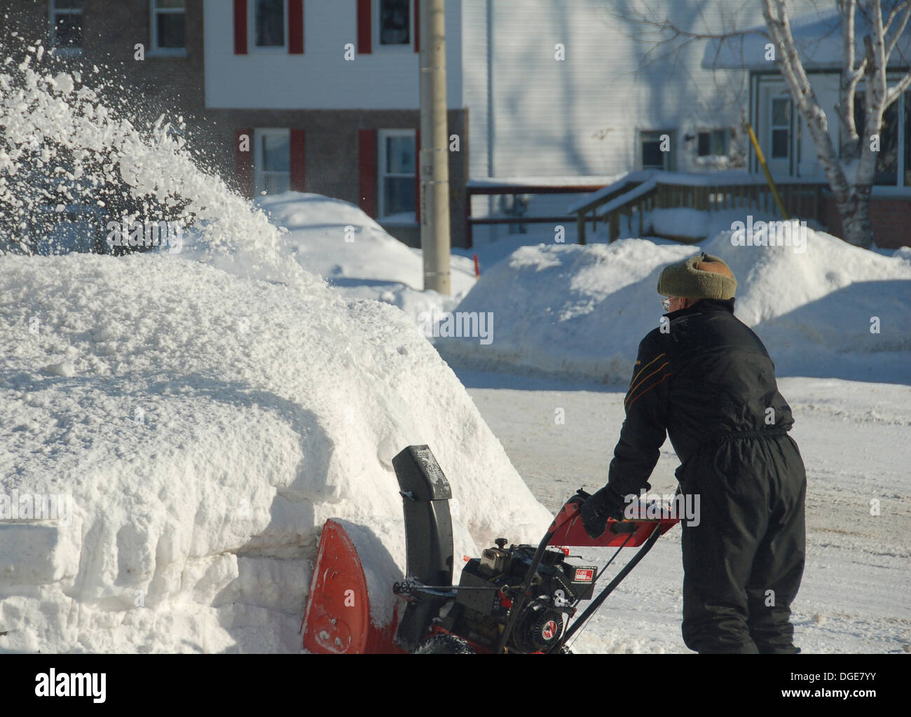 Man blowing snow off his driveway with snow blower Stock Photo - Alamy