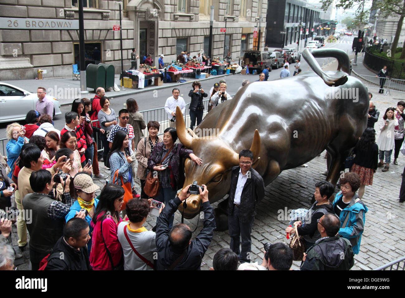 Tourists in New York City posing with the Charging Bull Sculpture near ...