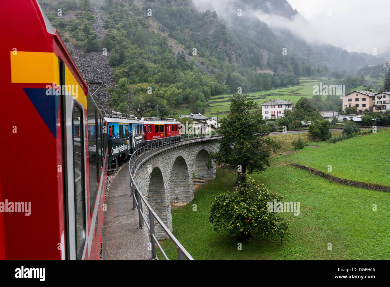 Swiss mountain train Bernina Express passes the spiral of the Brusio ...