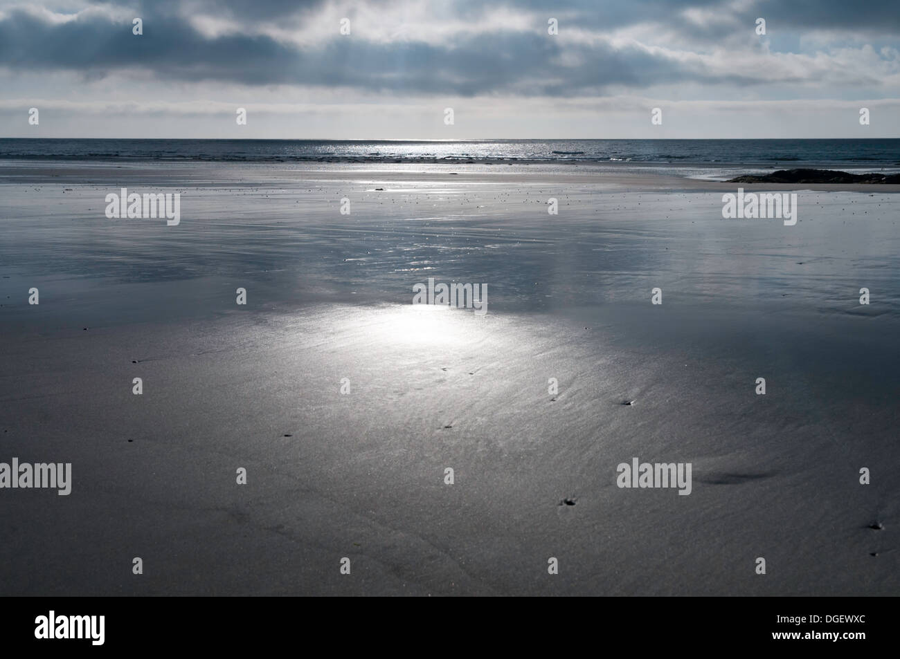 The Sun shinning on the sea and wet sand Stock Photo - Alamy