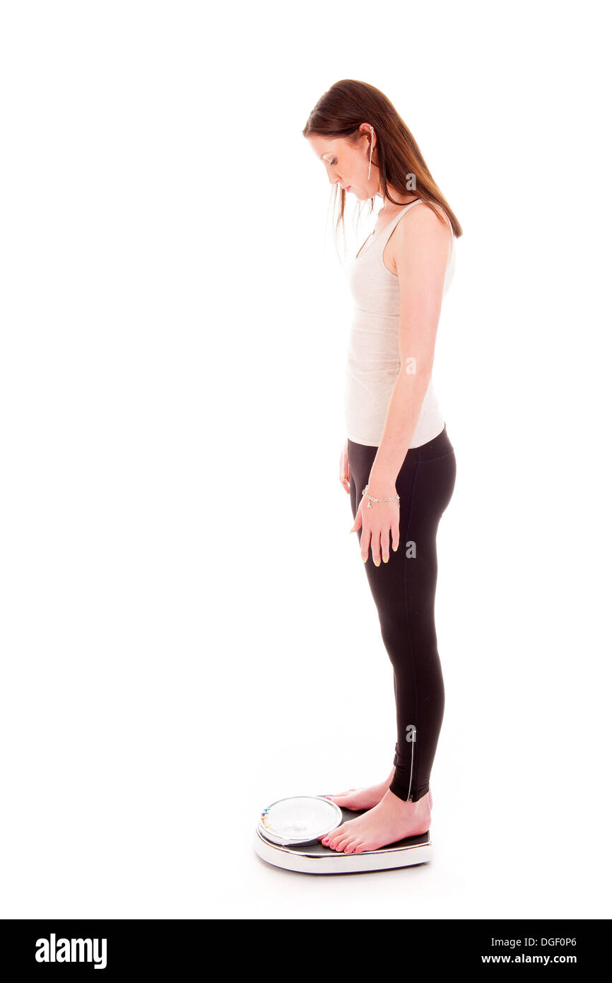 a girl on a weighing scale, disappointed of loosing to too little ...