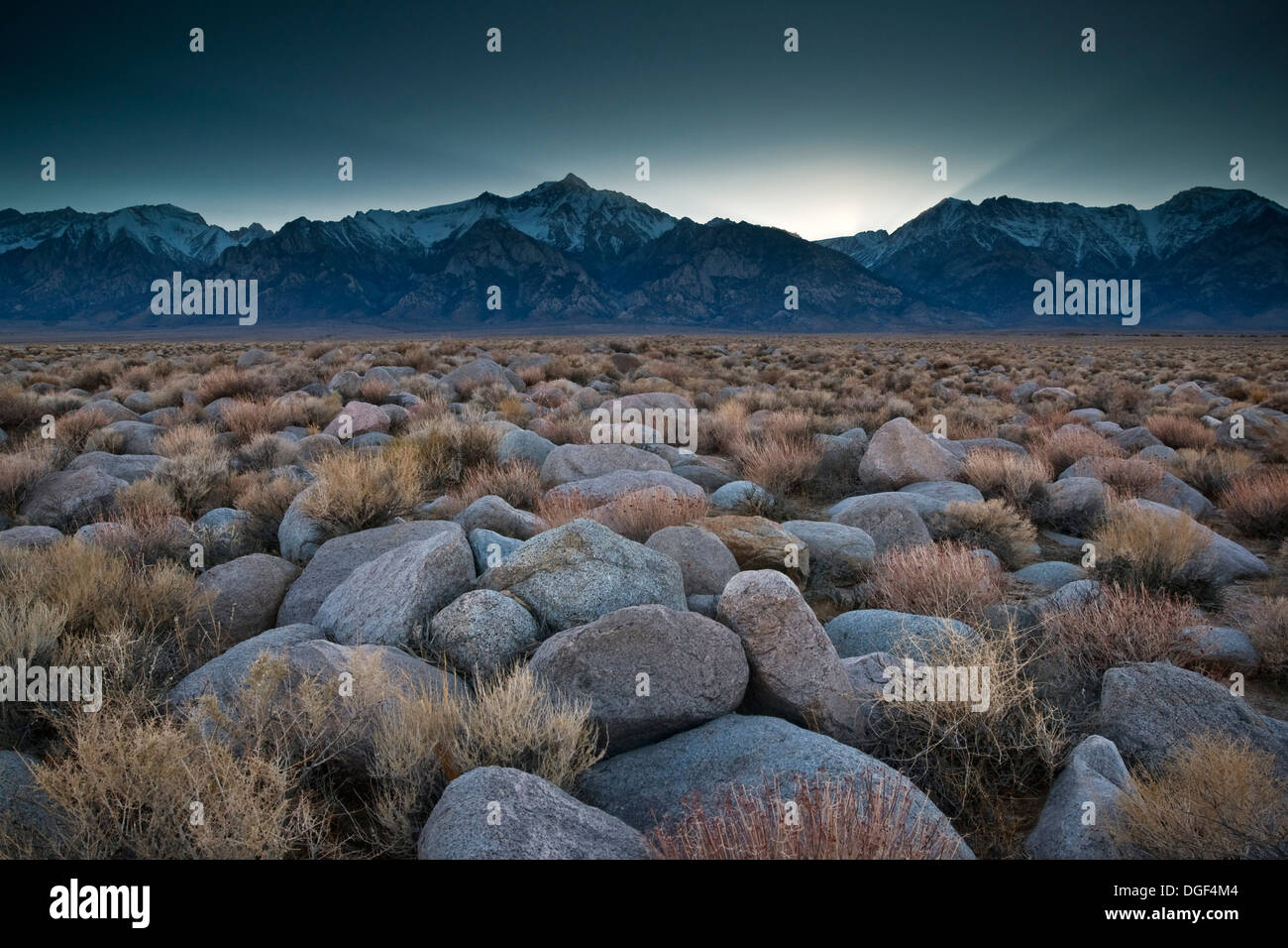 Rock field at sunset below the mountains of the Eastern Sierra, near ...