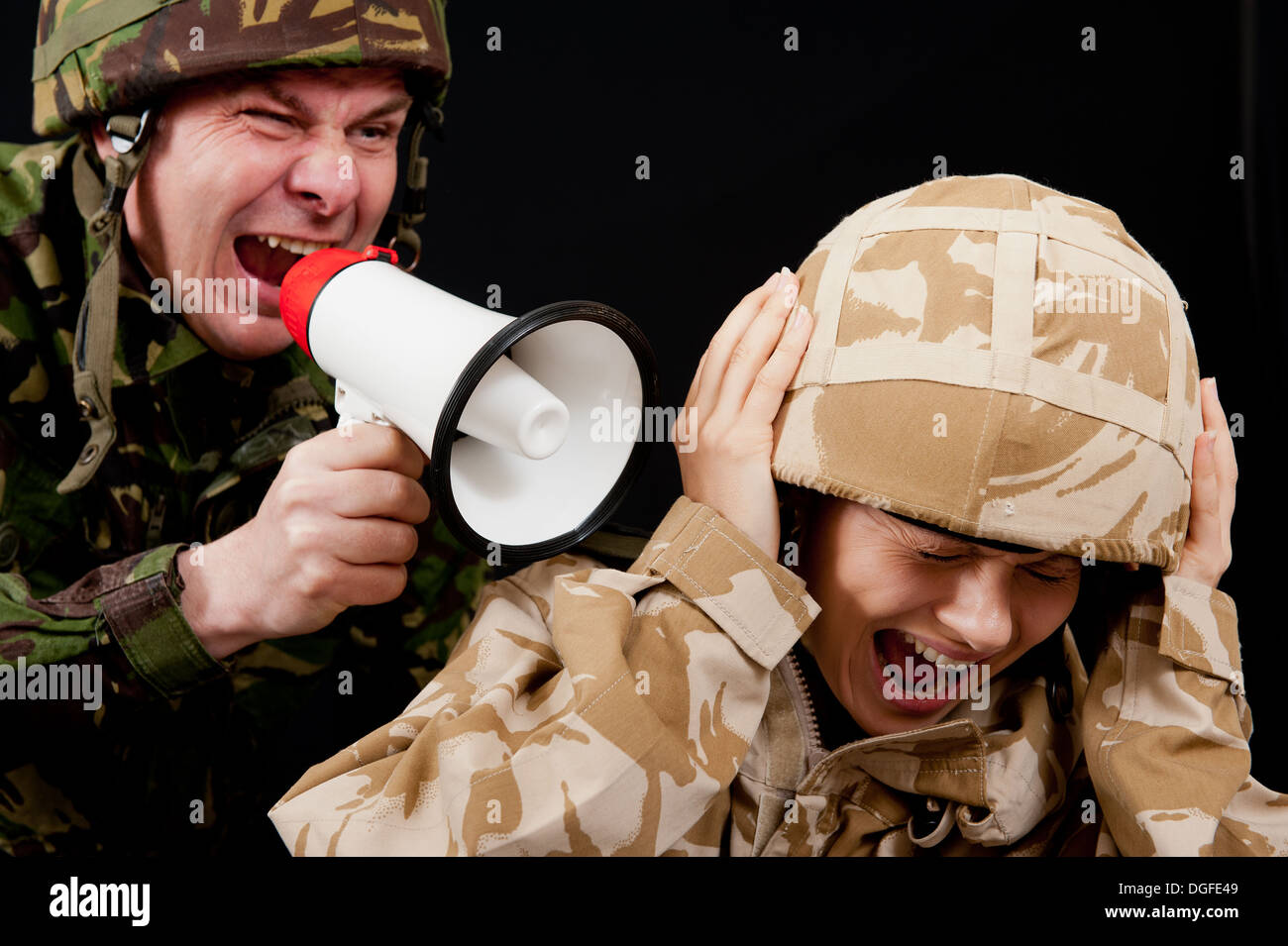 Male soldier shouting orders to a distraught female soldier with the ...