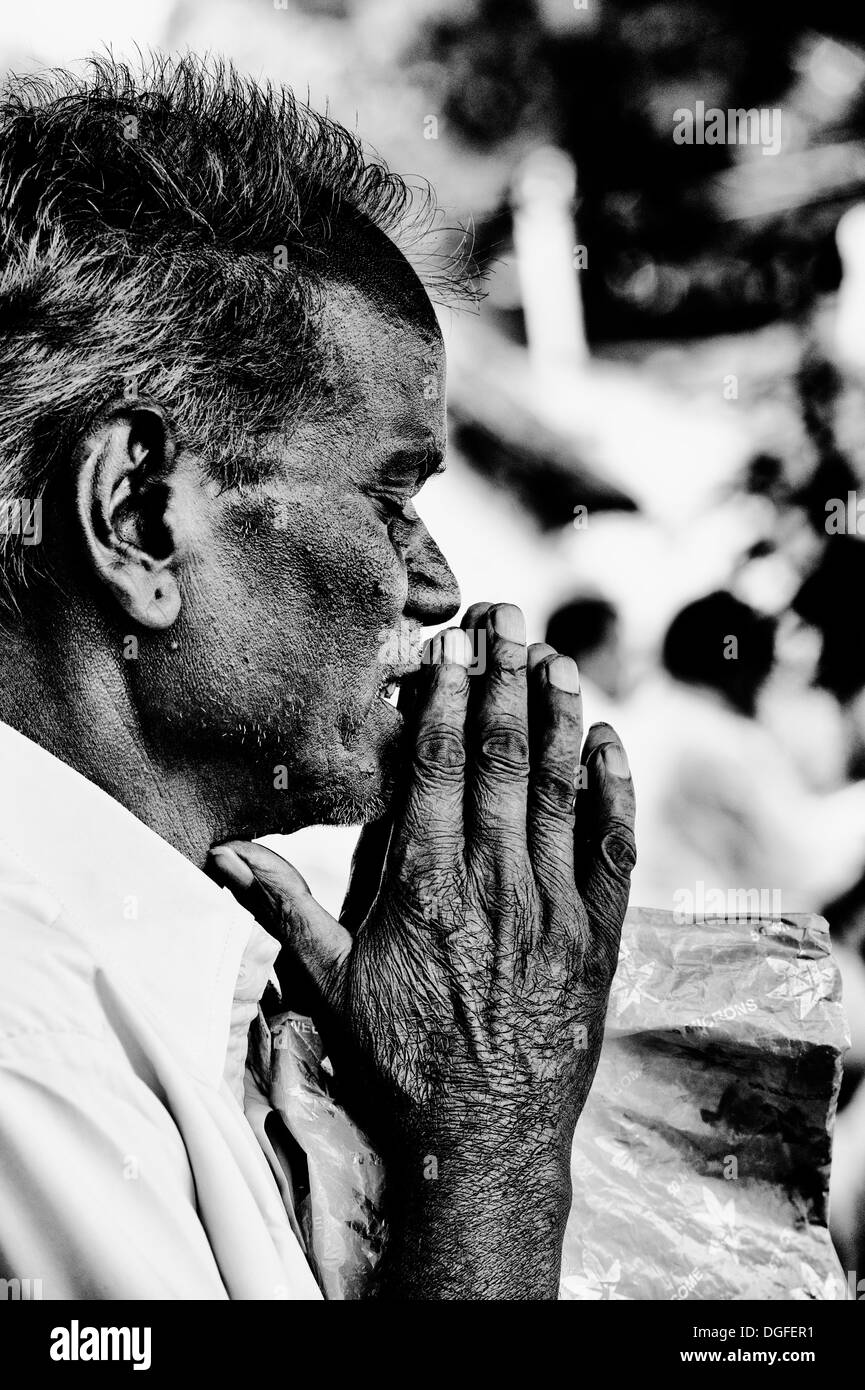 Indian man in prayer whilst waiting to be seen at Sri Sathya Sai Baba ...
