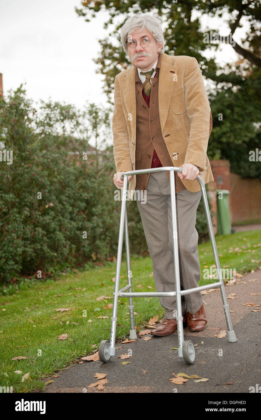 Grey haired old man walking along with his zimmerframe walking aid ...