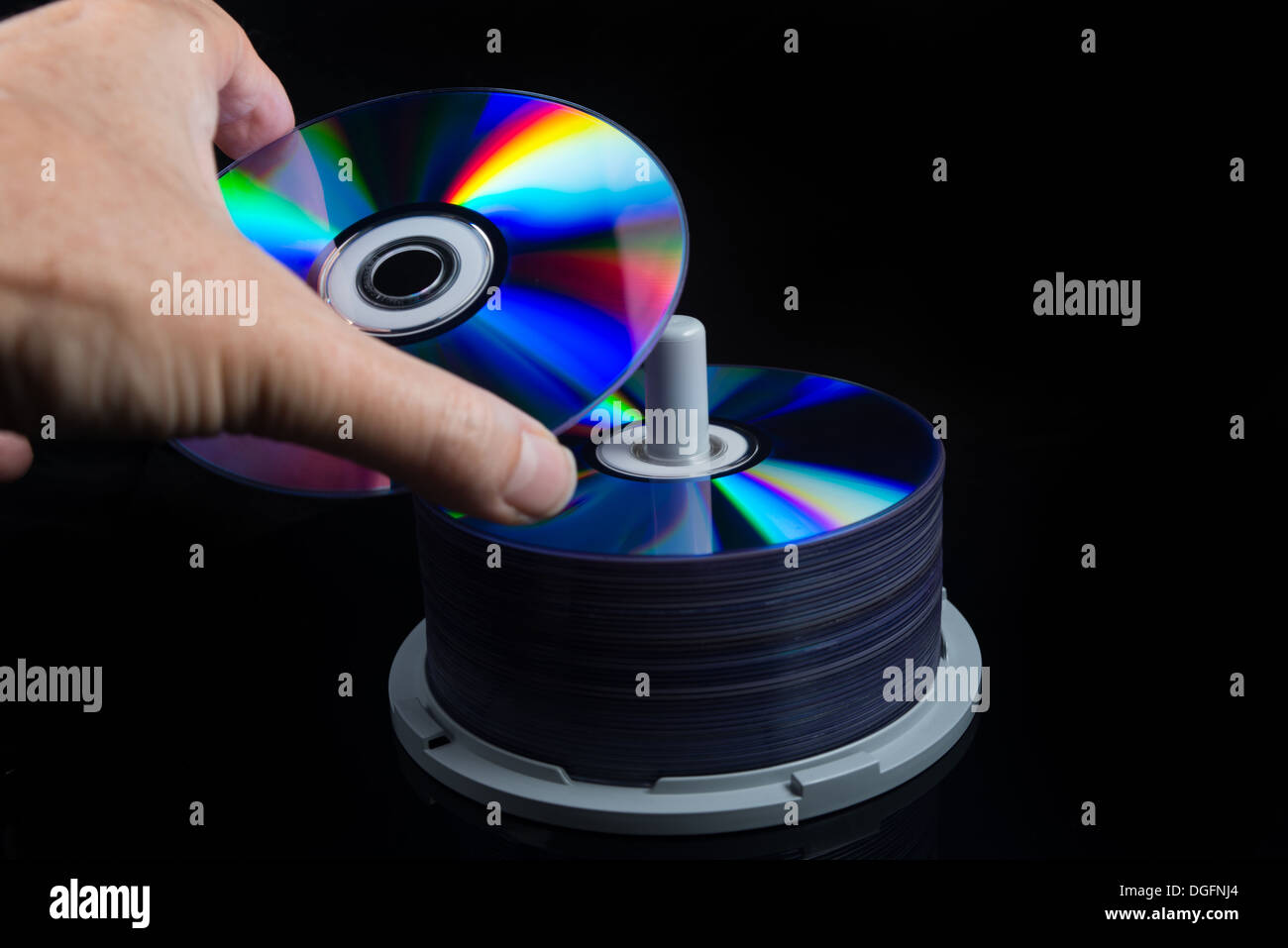 hand picking a dvd from a stack, cd, blu ray Stock Photo - Alamy