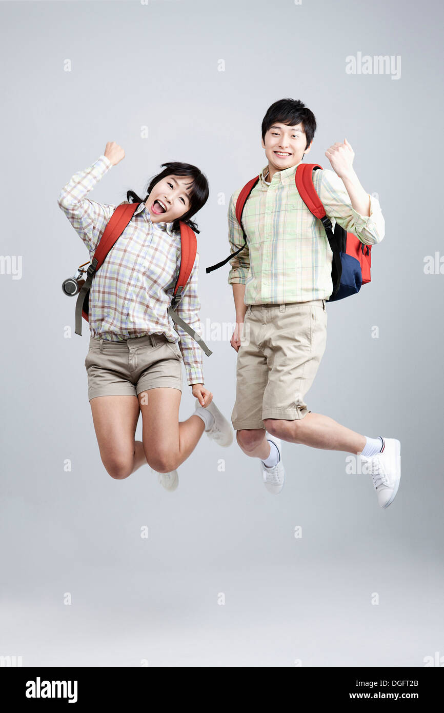 a couple with hiking gear jumping Stock Photo - Alamy
