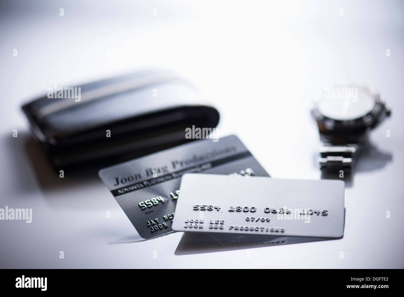 a wallet and credit cards next to a watch Stock Photo - Alamy