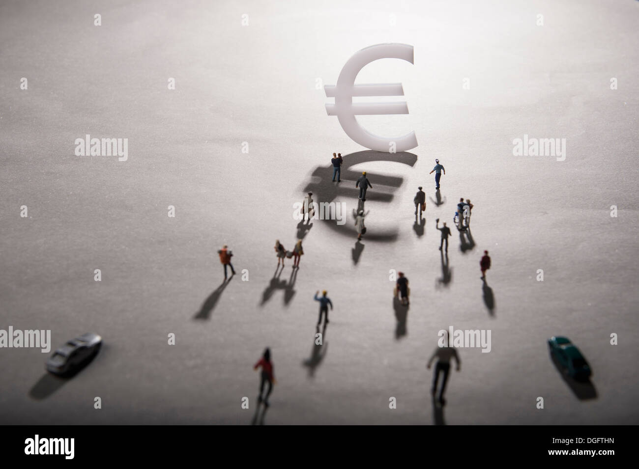 a euro sign with several toy people standing Stock Photo - Alamy