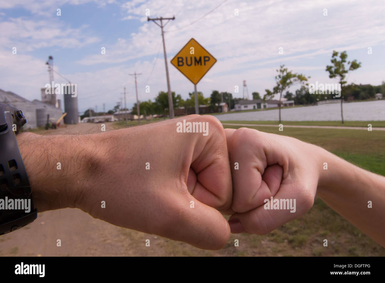 Two fists bumping by a road sign Stock Photo - Alamy