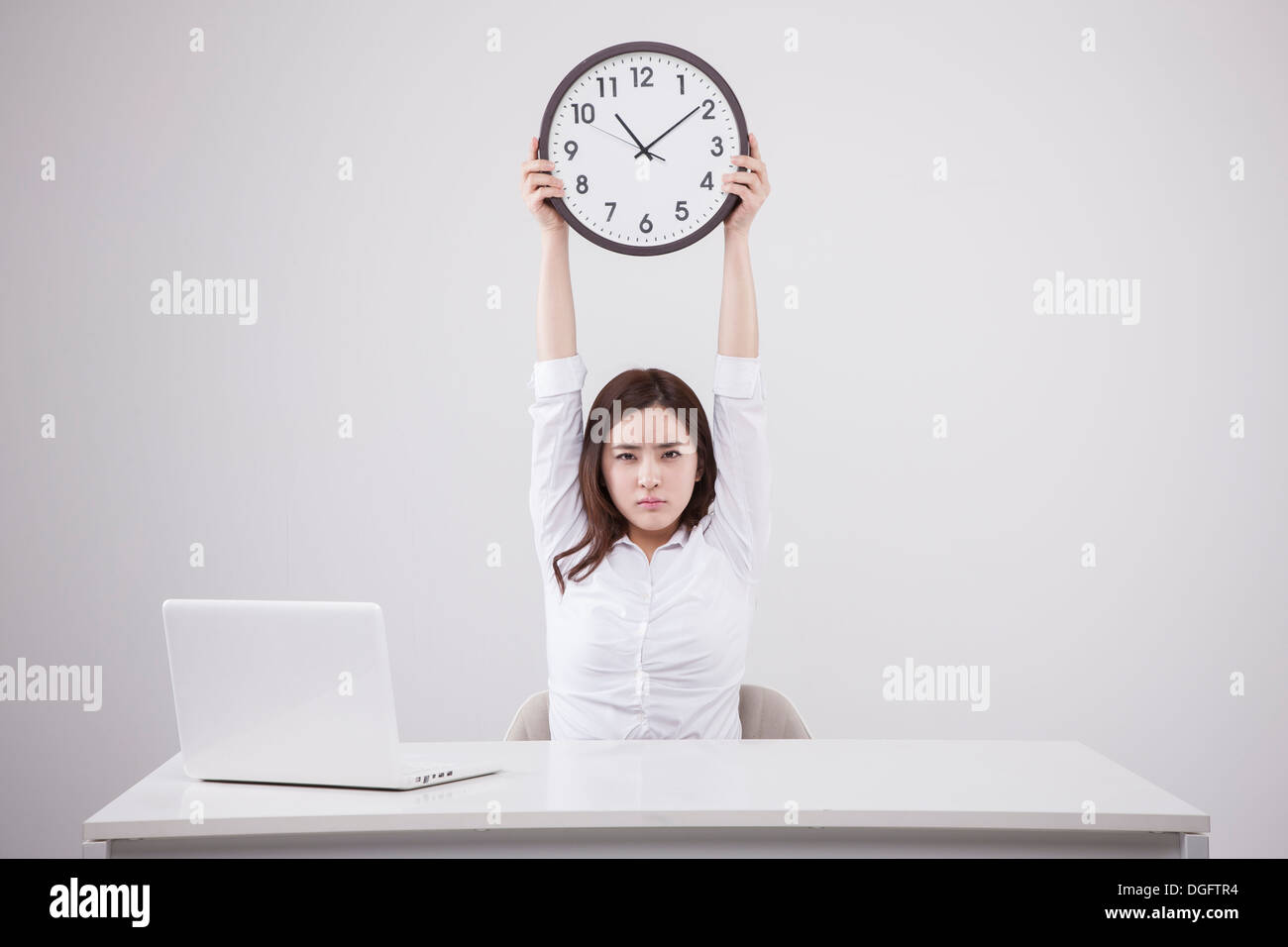 a business woman holding a clock Stock Photo - Alamy