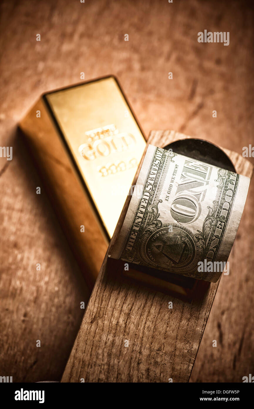 rolls of bills next to a gold bar Stock Photo - Alamy