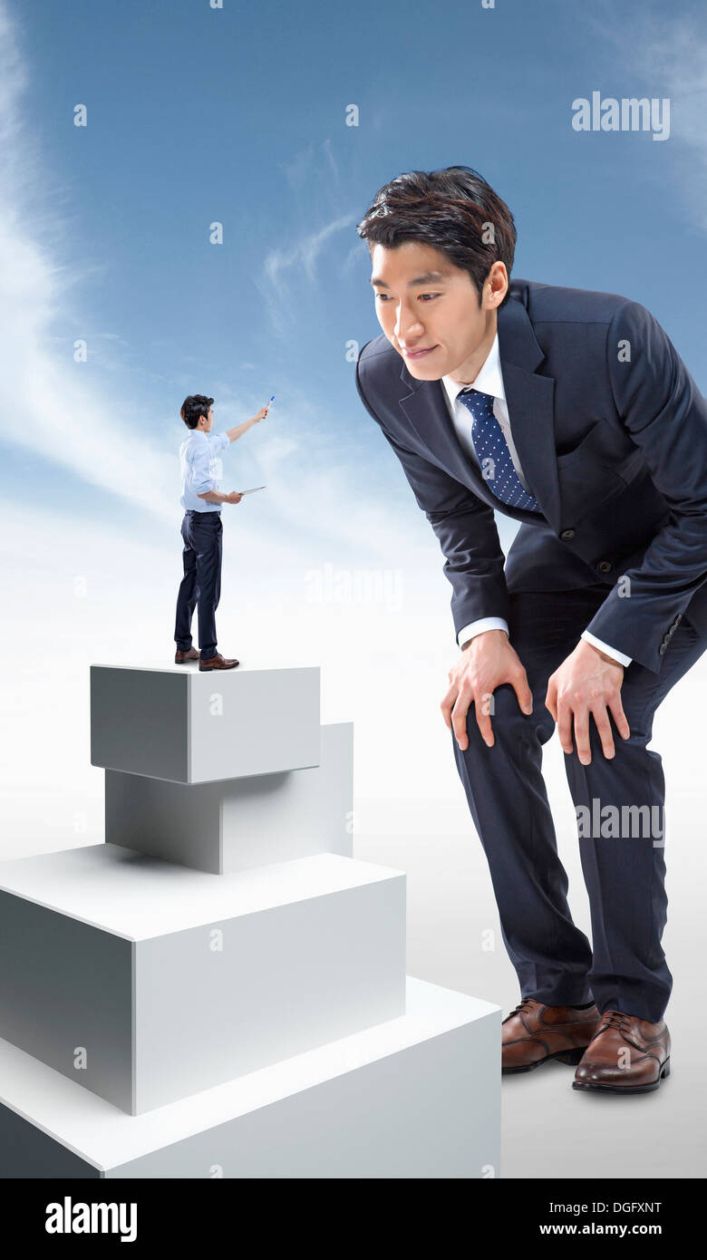 a business man talking to a giant business man Stock Photo - Alamy