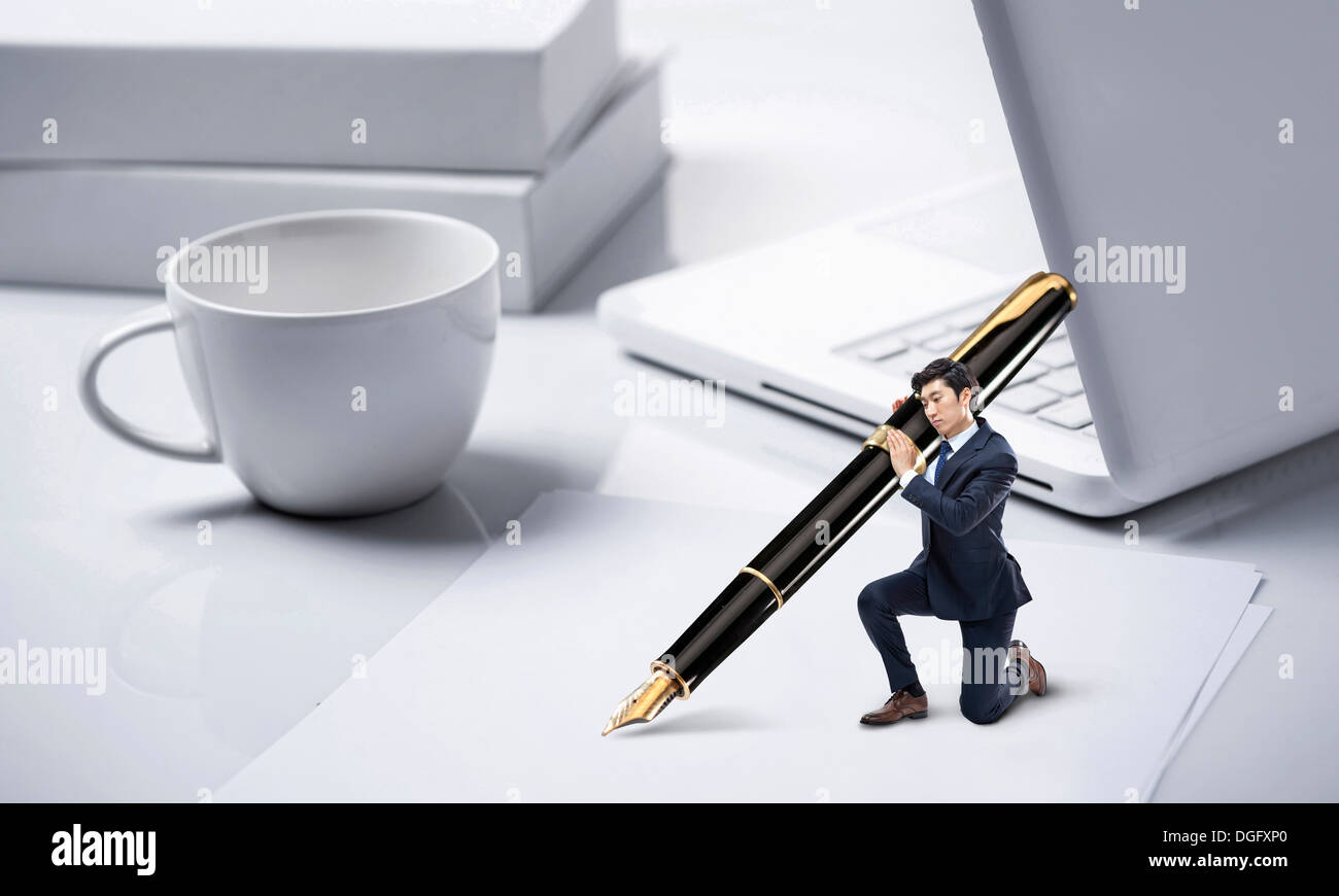 a tiny business man writing on a white paper Stock Photo - Alamy