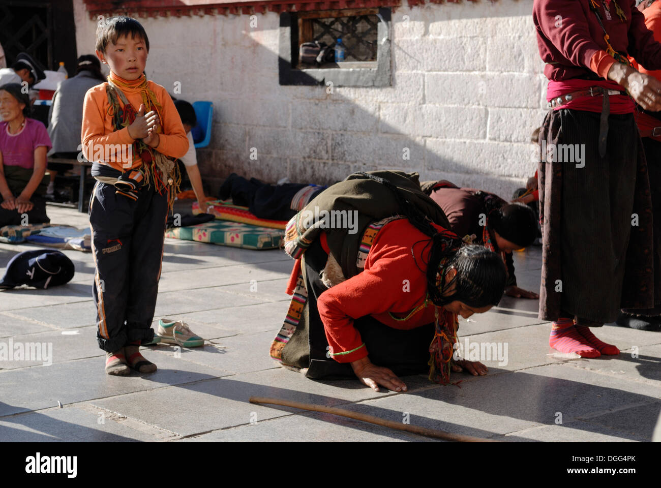 Tibetan pilgrims prostrating in front of Jokhang Temple, Lhasa, Tibet ...