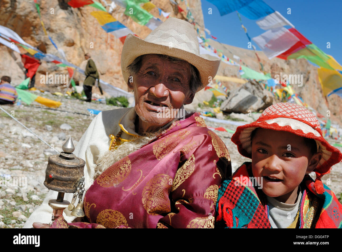 Tibetan pilgrim with a prayer wheel, prayer flags, Namtso Lake ...