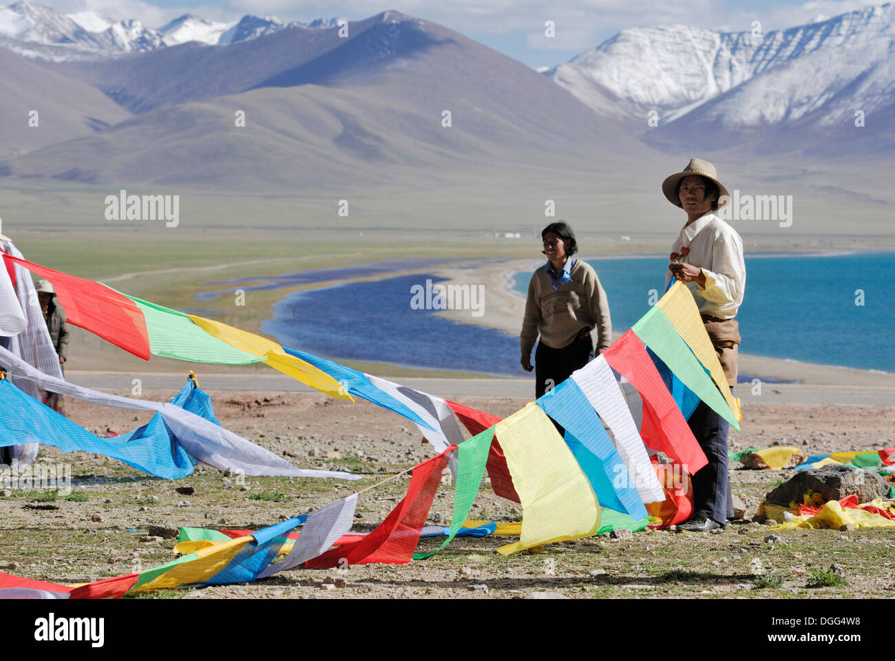 Tibetan pilgrims hanging prayer flags for the upcoming ceremony at ...