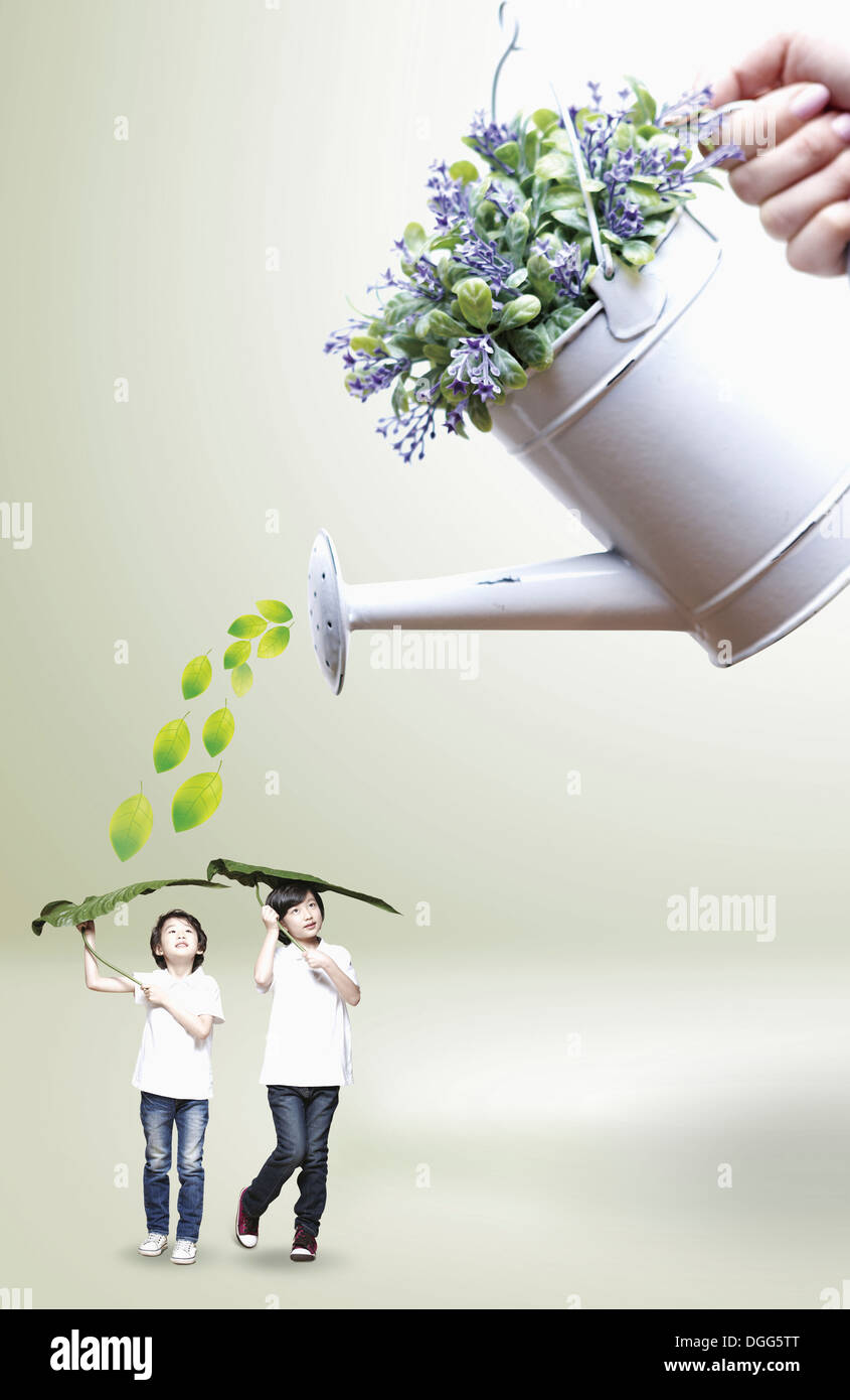 a water can watering two women Stock Photo - Alamy