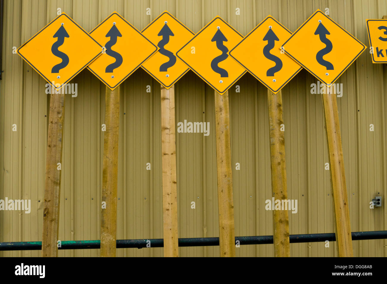 Roadside curve signs leaning on public works building Stock Photo - Alamy