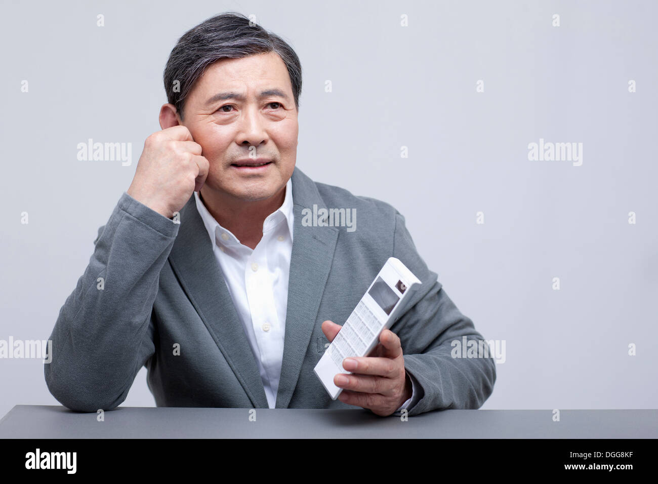 an old man holding a calculator Stock Photo - Alamy