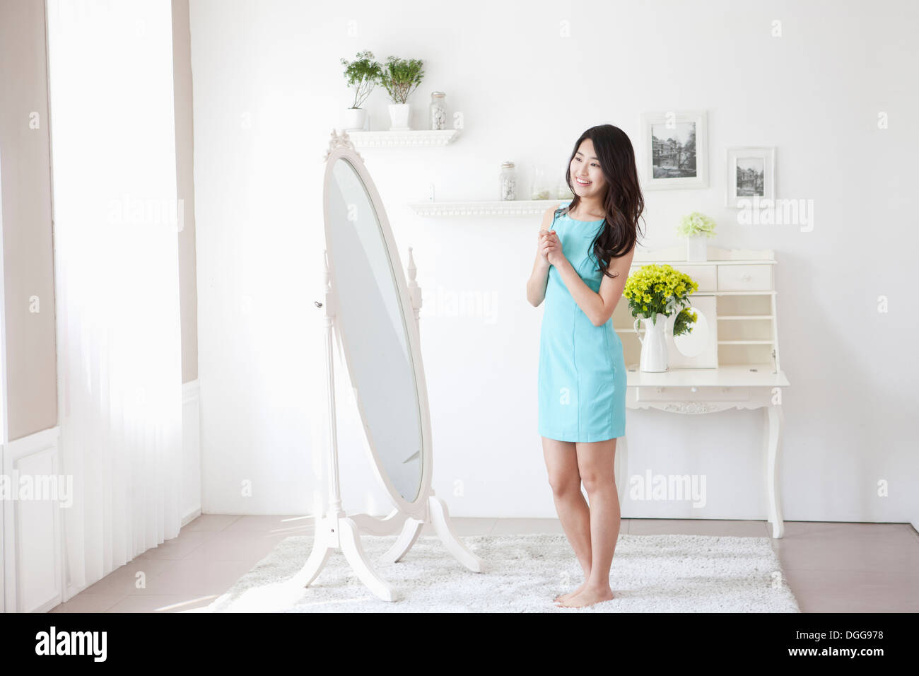 a young woman looking at her self in the mirror Stock Photo - Alamy