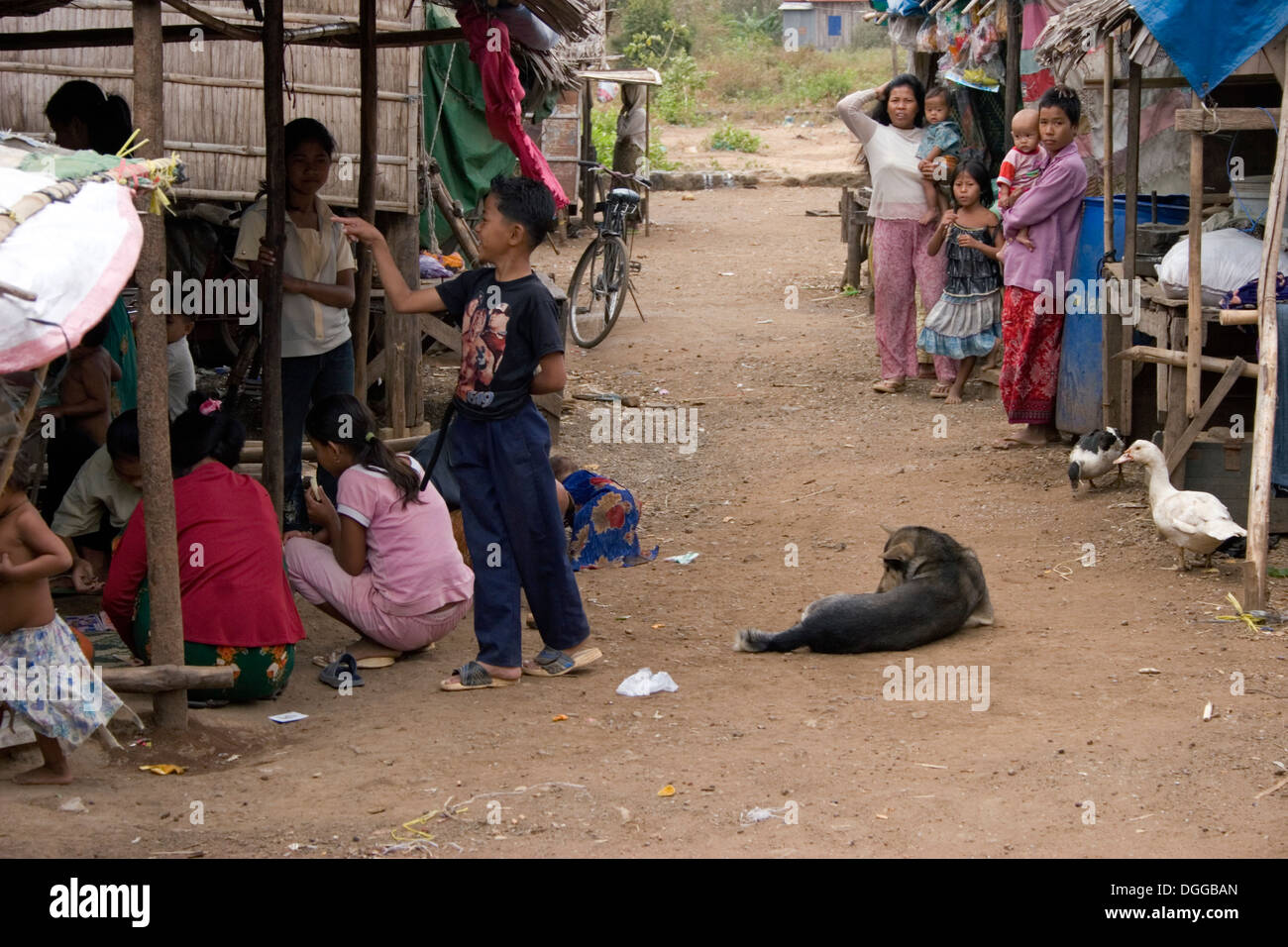 People are gathered outside their dilapidated shacks in a poverty ...