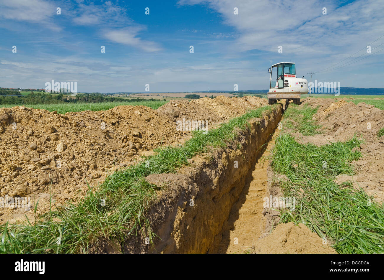 Excavator digging a ditch through agriculture landscape, Laurich ...