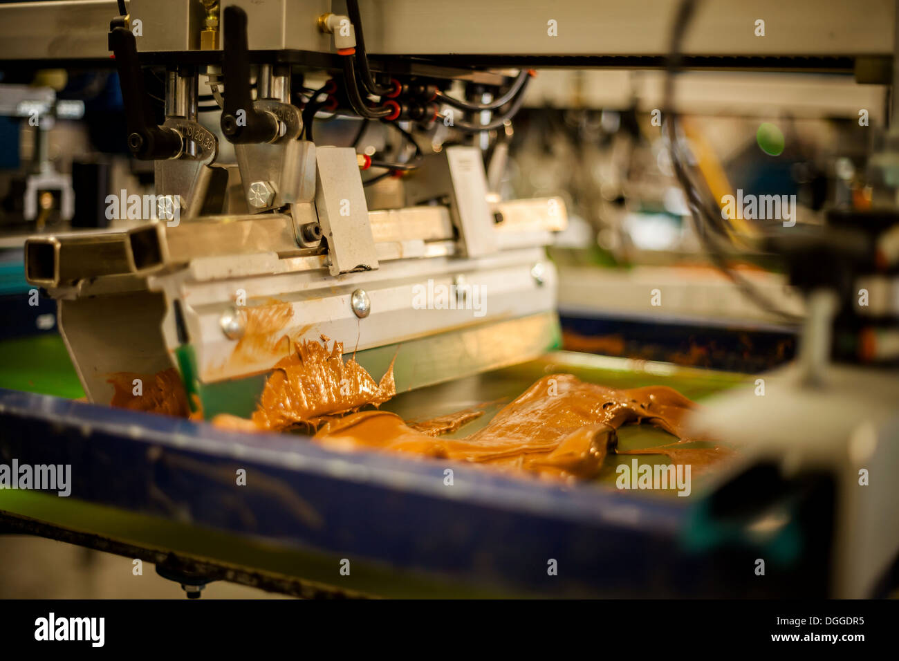 Screen print machine spreading ink on frame Stock Photo - Alamy
