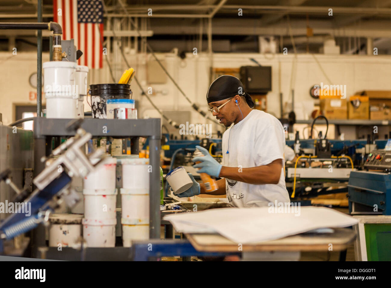 Worker picking up ink in screen print workshop Stock Photo - Alamy