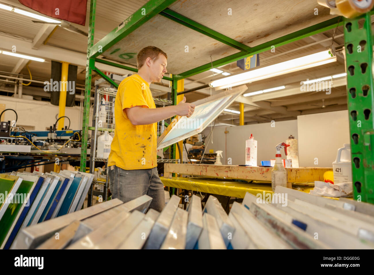 Worker carrying frame in screen printing workshop Stock Photo - Alamy