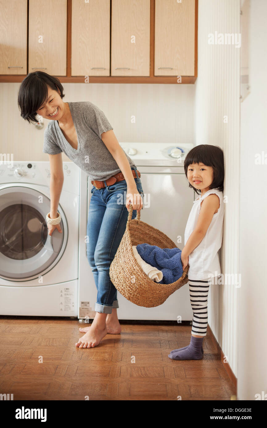 Mother and daughter with laundry basket Stock Photo - Alamy