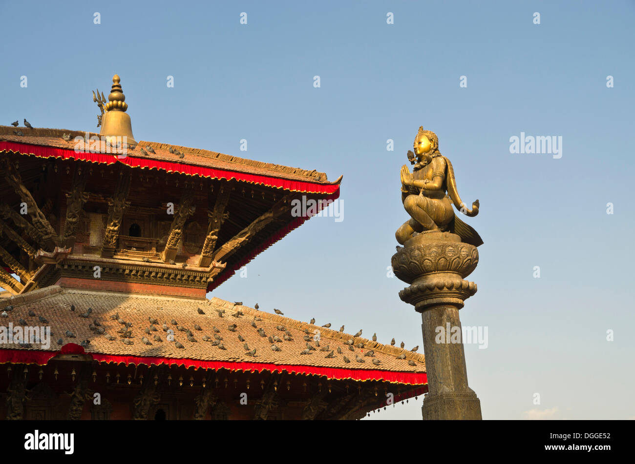 Statue of Garuda on Patan Durbar Square, the roof of a temple at the ...