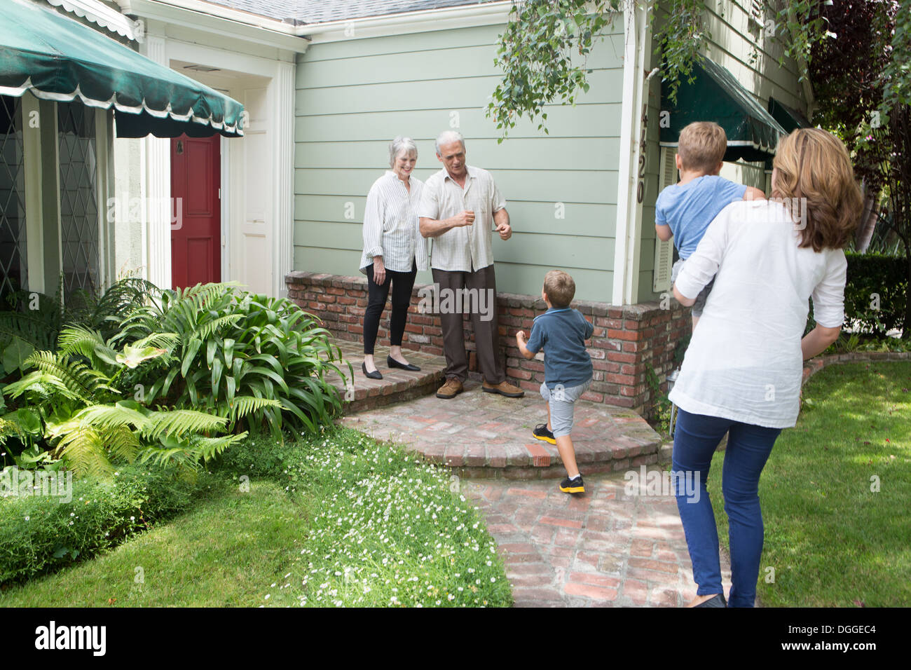 Senior couple greeting family at home Stock Photo - Alamy