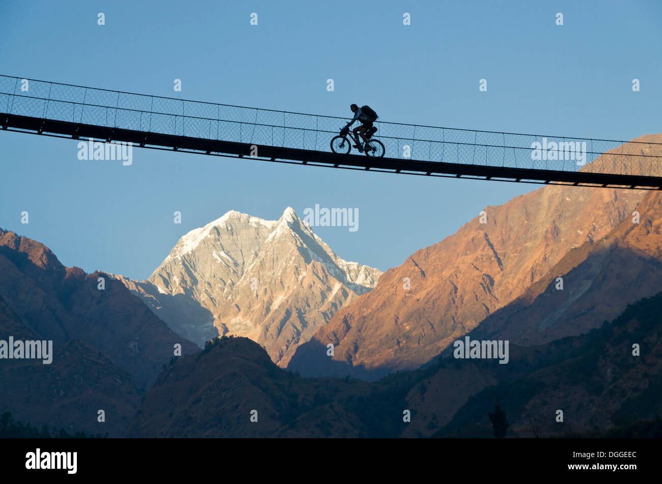Cyclist crossing a suspension Bridge over Kali Ghandaki Valley, Nilgiri ...