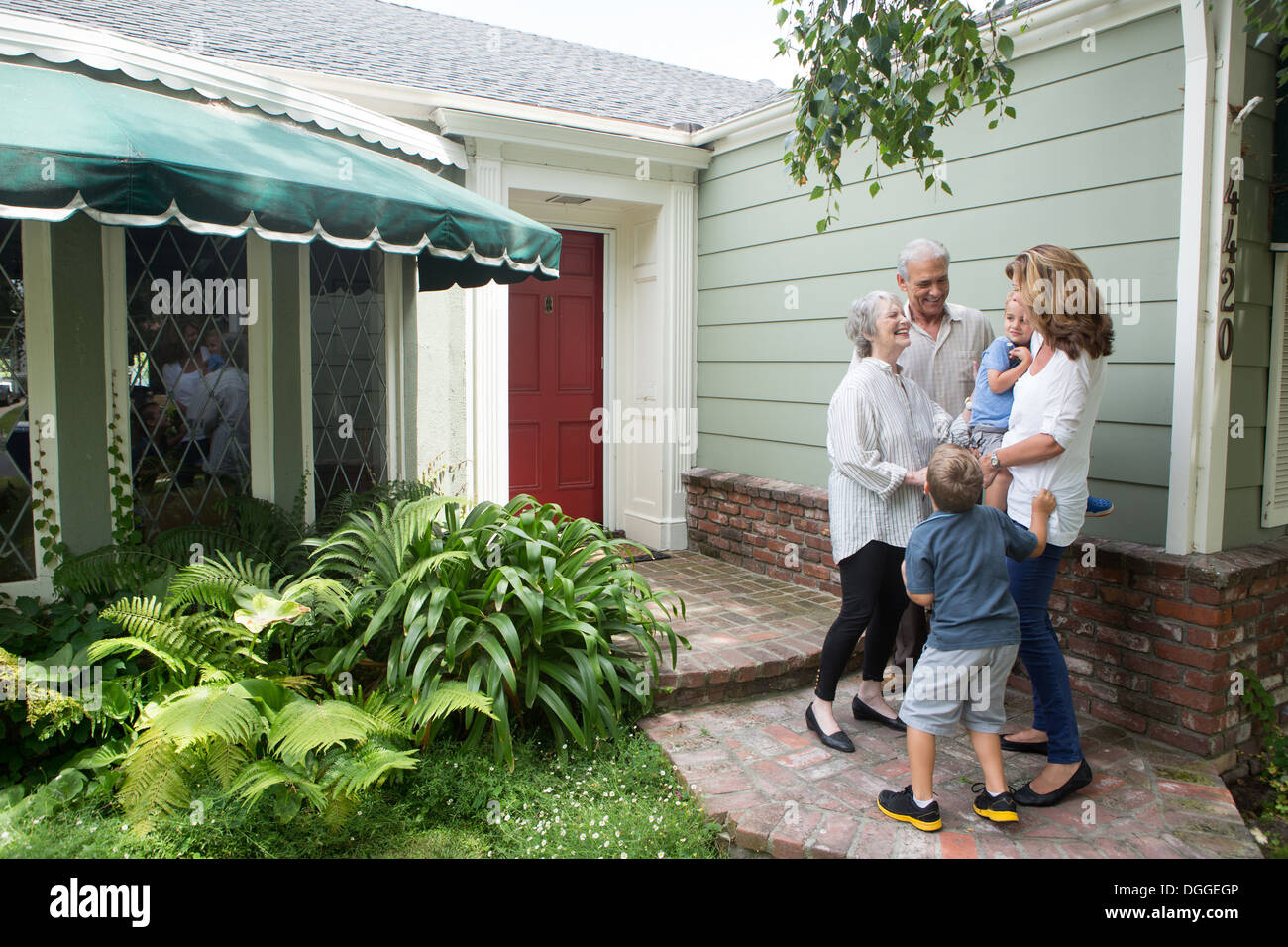 Senior couple greeting family at home Stock Photo - Alamy