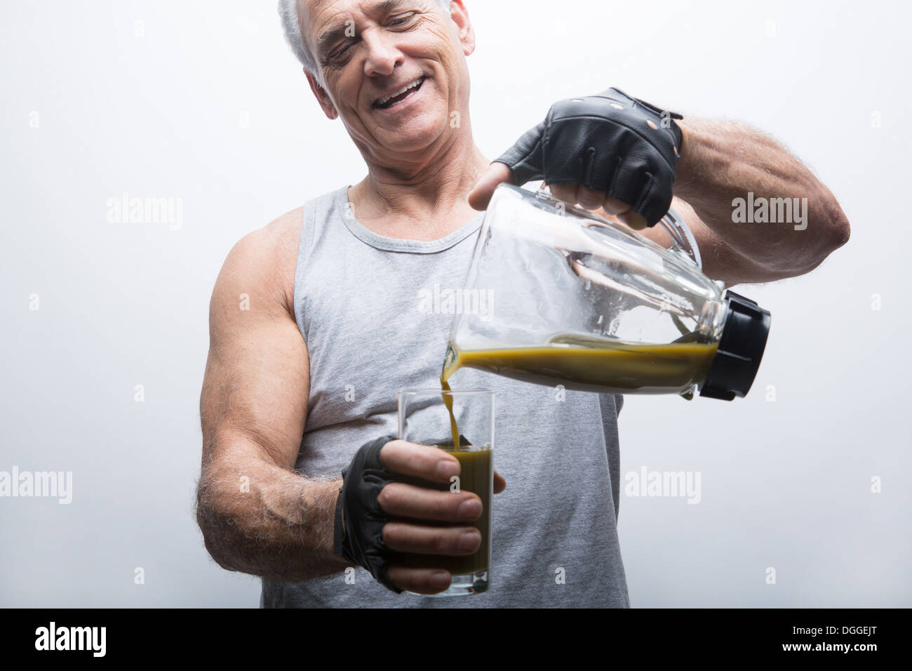 Senior man pouring smoothie from blender into glass Stock Photo - Alamy