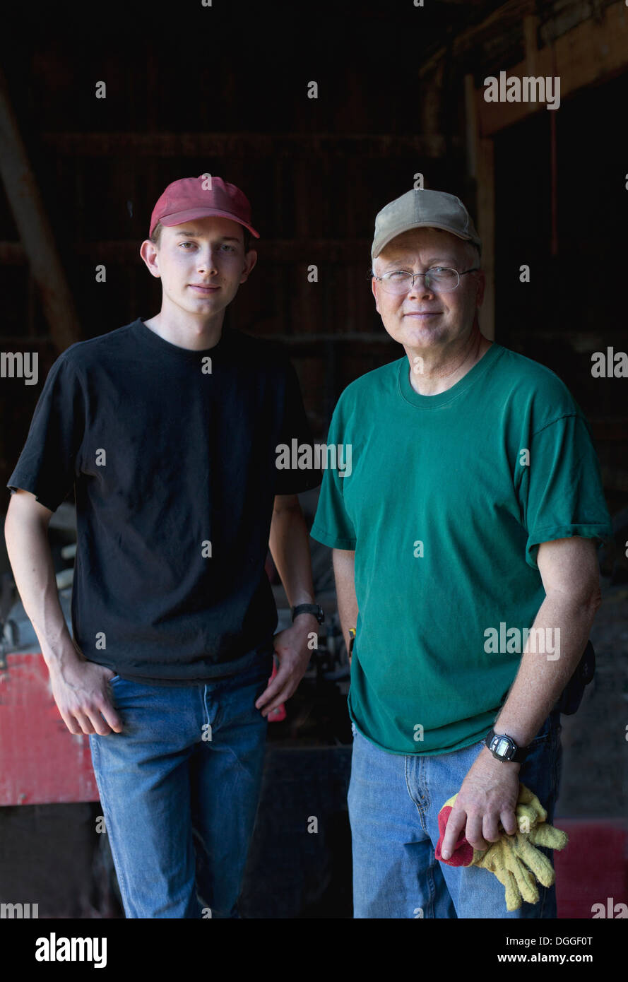 Mature farmer and son in barn, portrait Stock Photo - Alamy