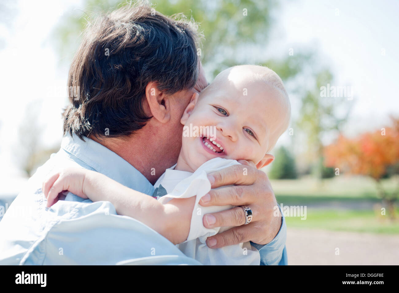 Close up of grandfather hugging grandson Stock Photo - Alamy